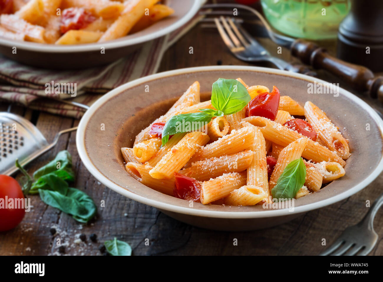 Plate of pasta penne with cherry tomato sauce, fresh basil and grated ...