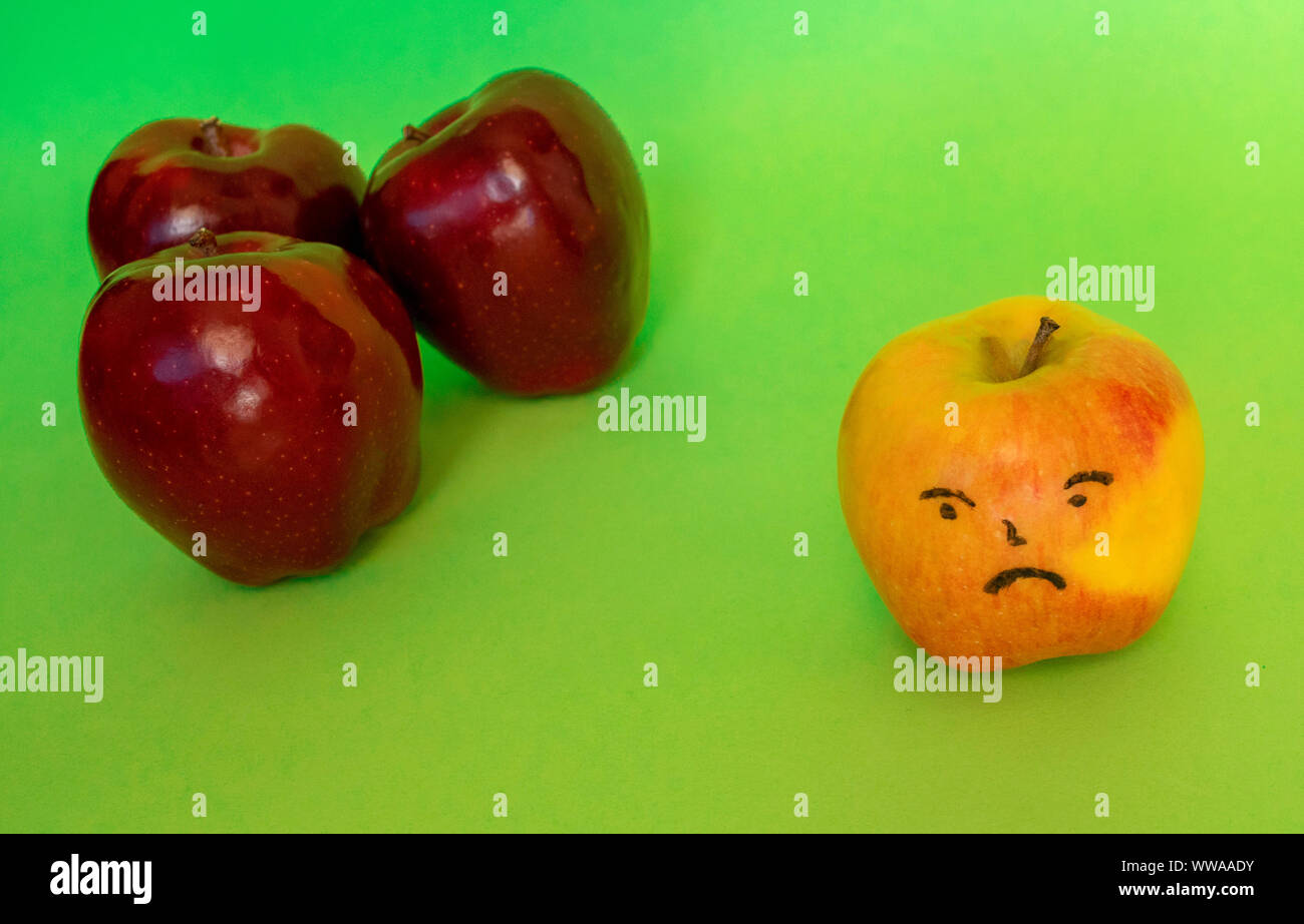 Angry apple face on green background Stock Photo - Alamy