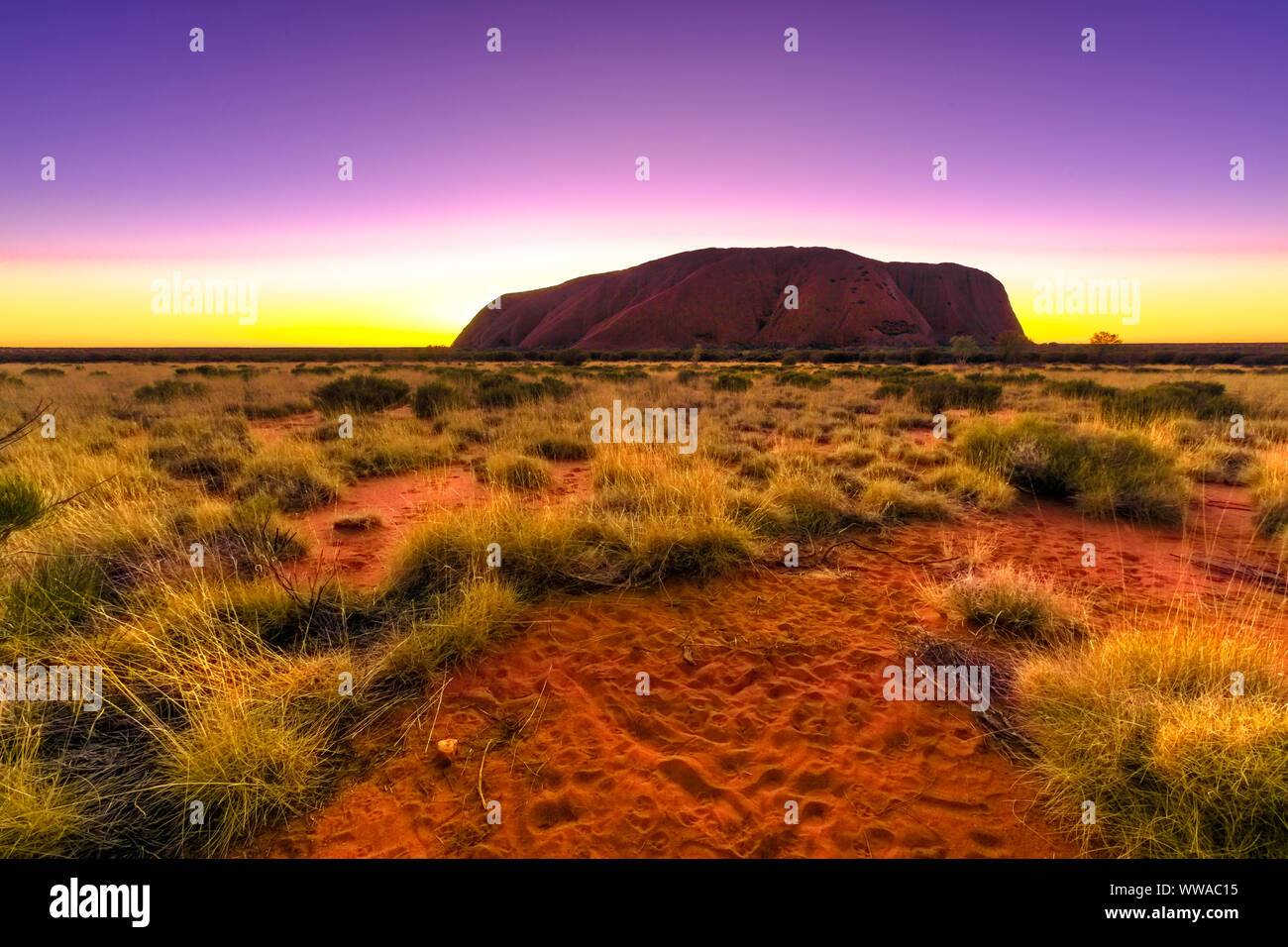 Dramatic dawn sky behind monolith Ayers Rock. Colors of sky at Uluru at ...
