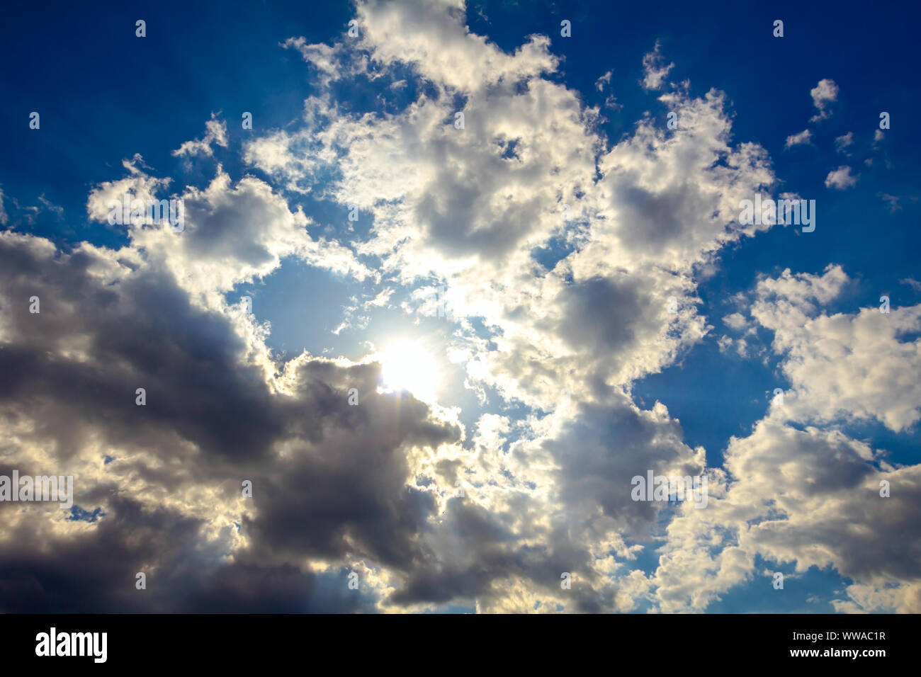 Rays of the sun break through the gray clouds, cumulus cloudscape Stock ...