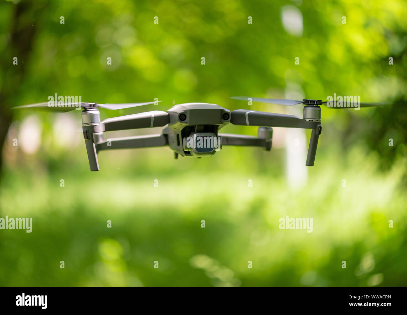Flying drone with camera hovering inside a forrest, natural background ...