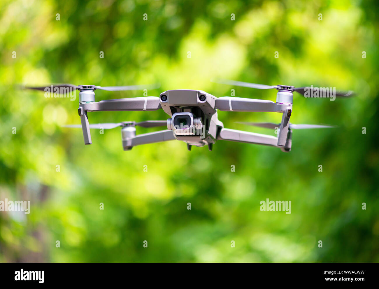 Flying drone with camera hovering inside a forrest, natural background ...