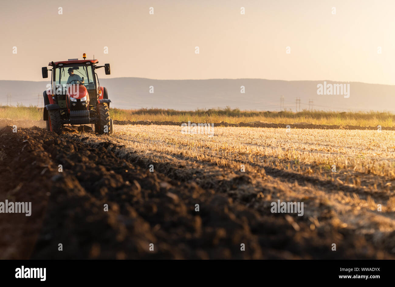 Tractor plowing fields -preparing land for sowing Stock Photo - Alamy