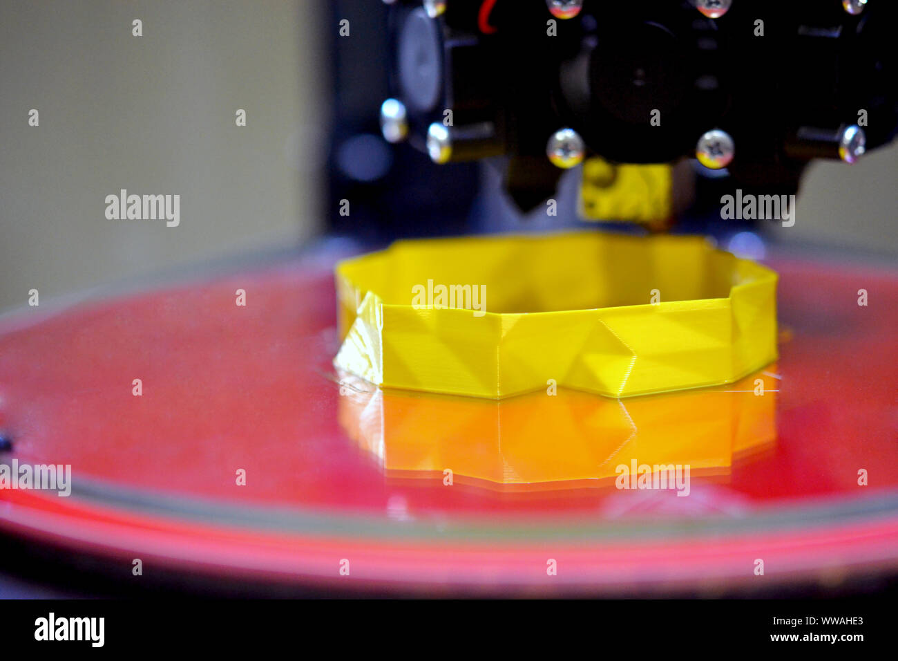 3d printer while printing a yellow object close-up close-up ...