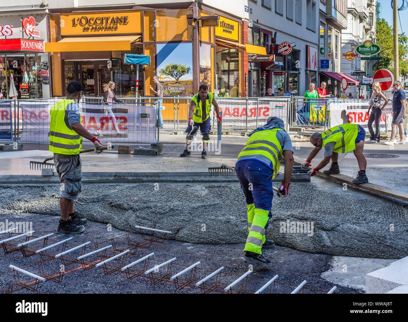Workers spreading poured concrete into new road foundations - Vienna ...