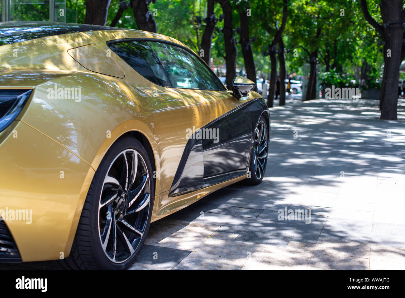 Unrecognizable sports car. A sidewalk in a trendy area of Beijing ...