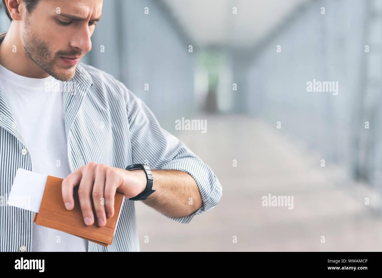 Worried man looking at watch, waiting for boarding at airport Stock ...