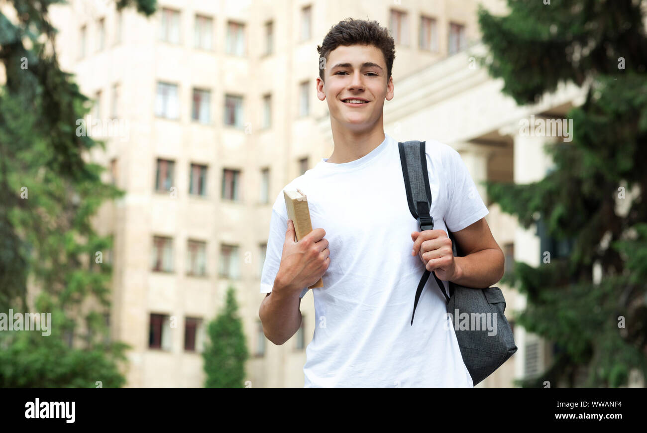 Education concept. Student guy walking near university Stock Photo - Alamy