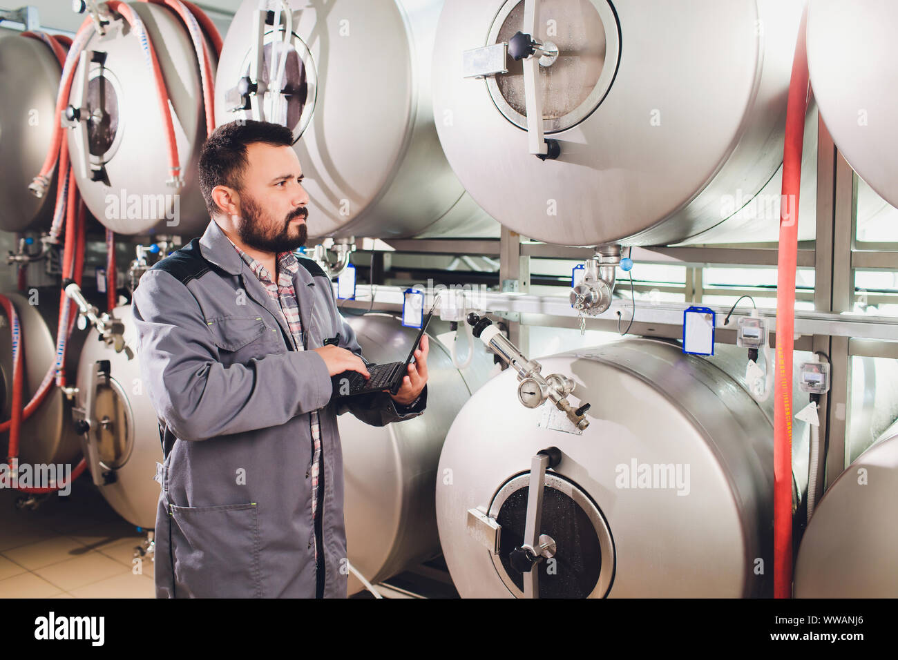 Portrait of brewer who is making beer on his workplace in the brew ...