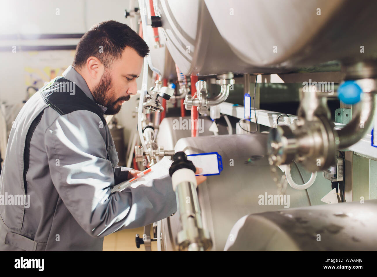 Portrait of brewer who is making beer on his workplace in the brew ...