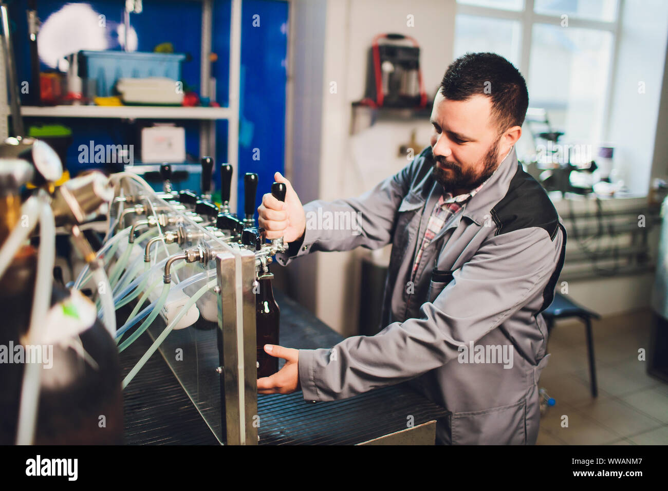 Portrait of brewer who is making beer on his workplace in the brew ...