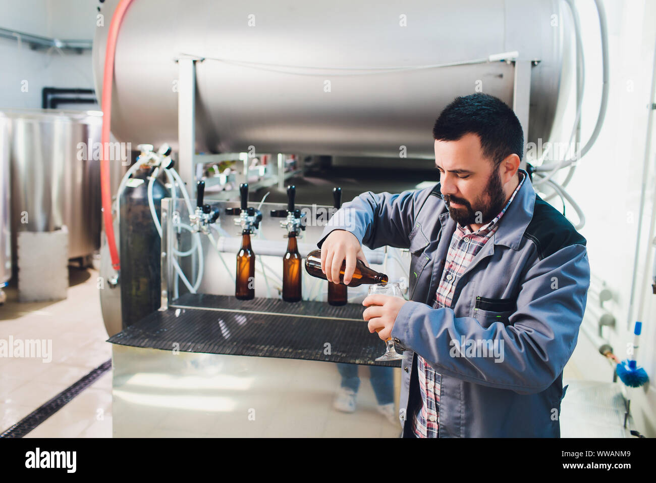 Portrait of brewer who is making beer on his workplace in the brew ...