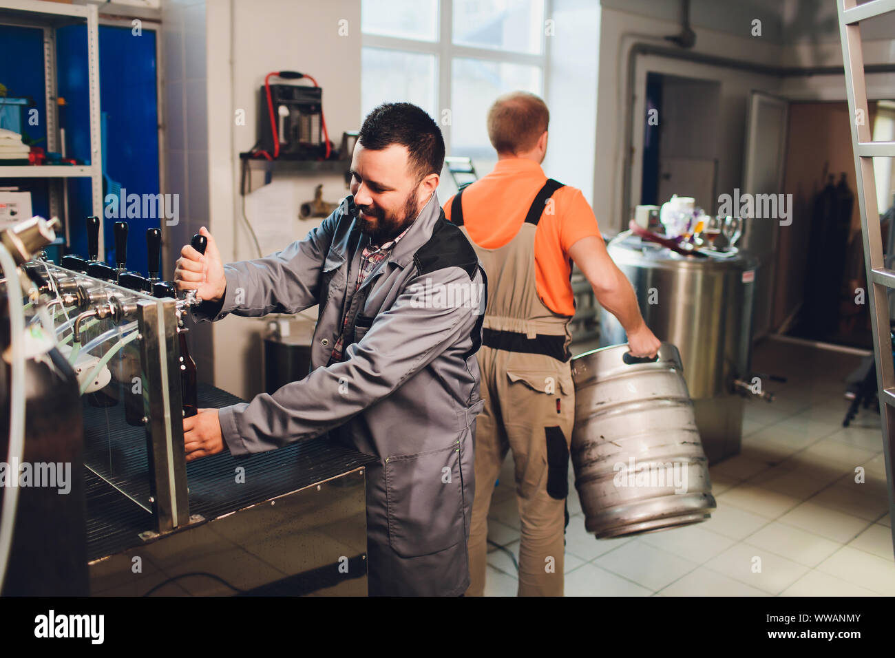 Portrait of brewer who is making beer on his workplace in the brew ...