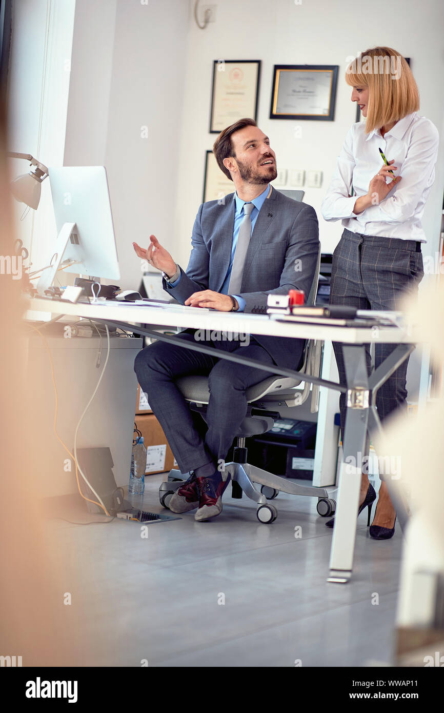 Smiling business man at office with employees working Stock Photo - Alamy