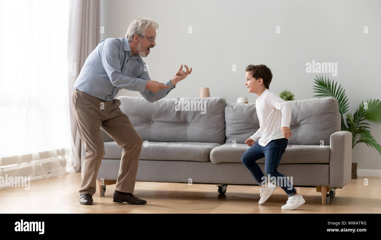 Cute boy grandson dancing with old grandpa in living room Stock Photo ...