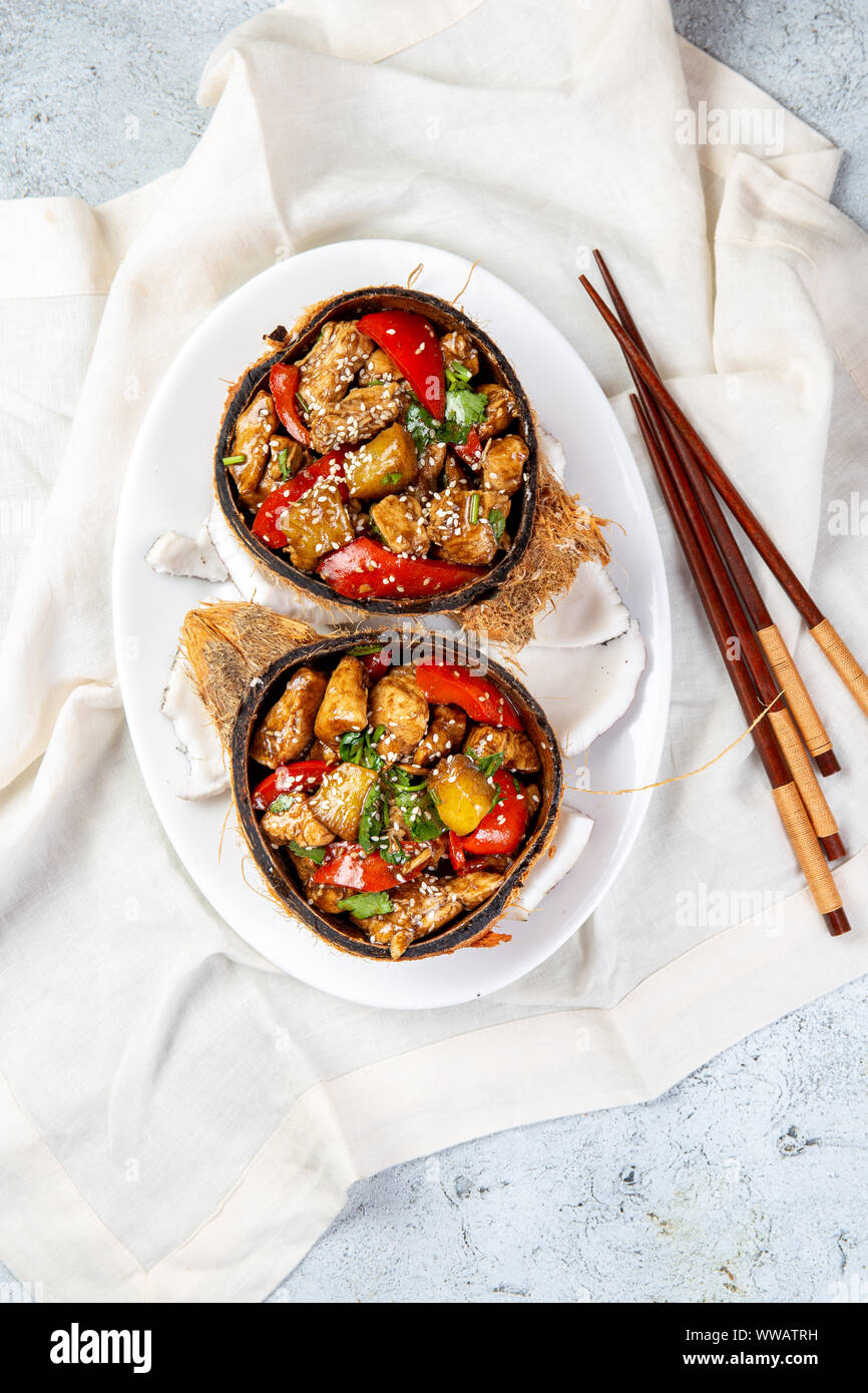 Hawaiian pinapple chicken in natural coconut shell plates on white ...