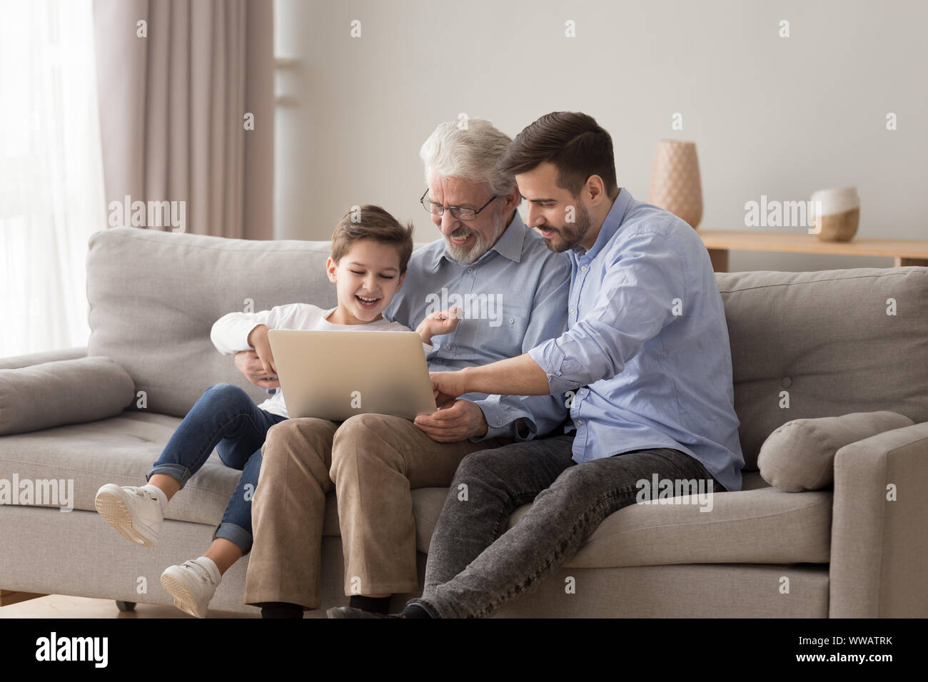 Happy three generation family grandfather father and grandson using ...