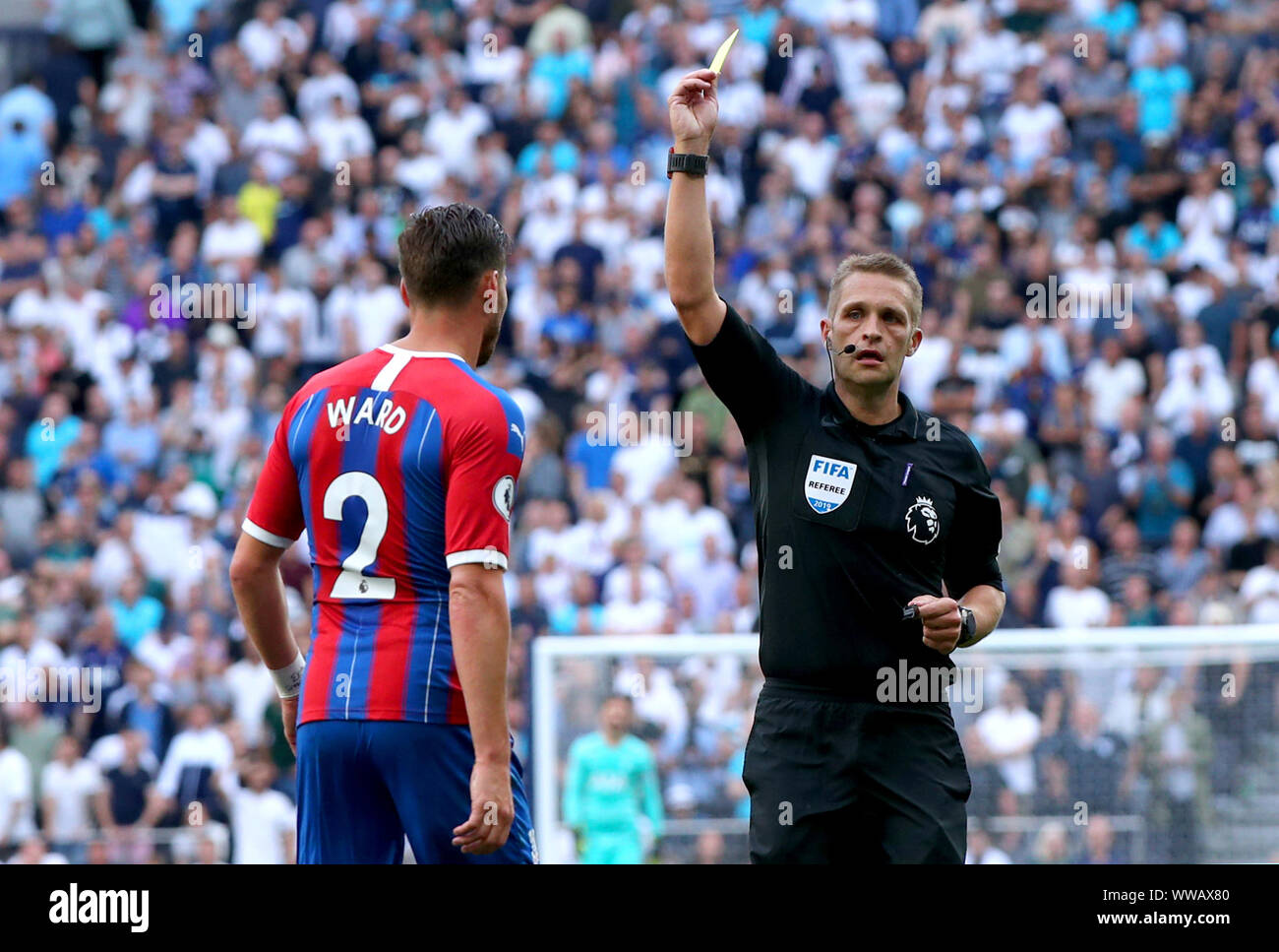 Referee Craig Pawson (right) shows Crystal Palace's Joel Ward a yellow card during the Premier ...