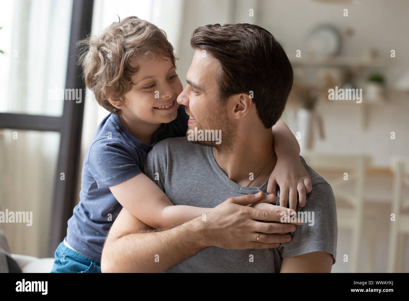 Joyful little preschool boy hugging from back father Stock Photo - Alamy