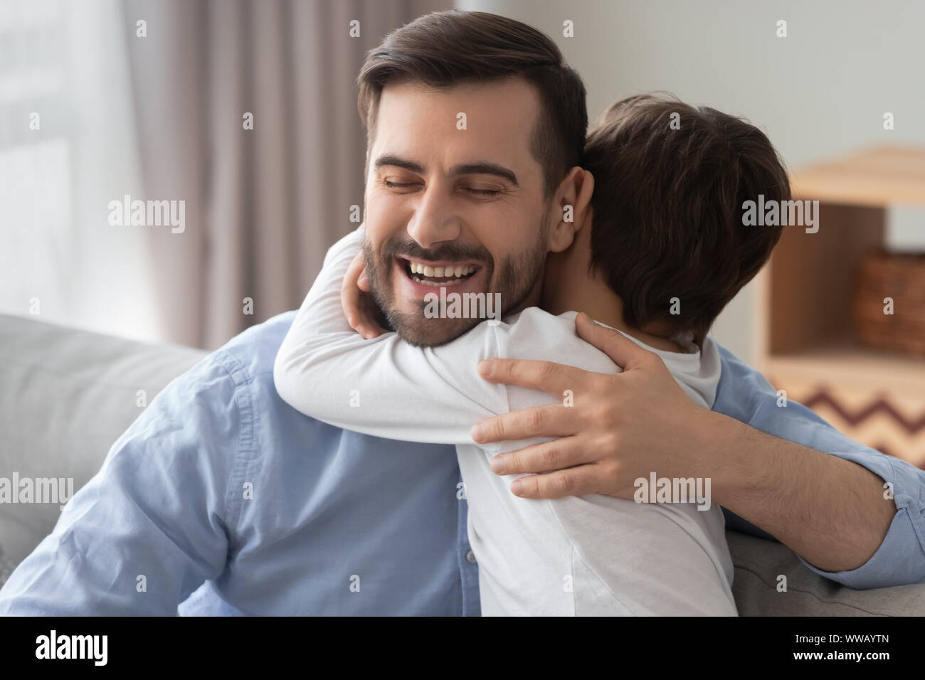 Cute kid son embracing affectionate dad congratulating on fathers day ...