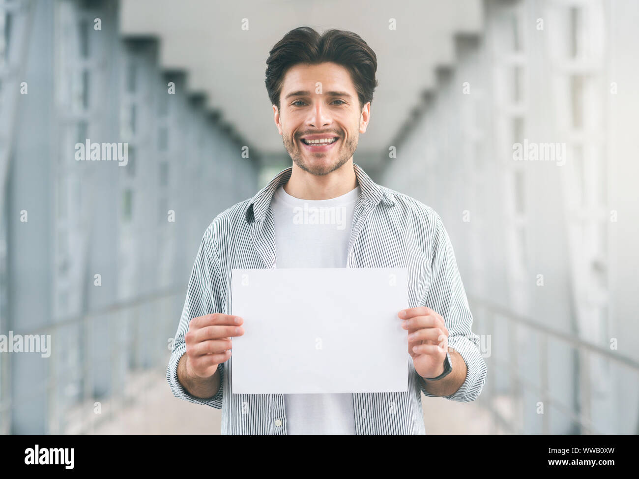 Friendly millennial man holding name board at airport Stock Photo - Alamy