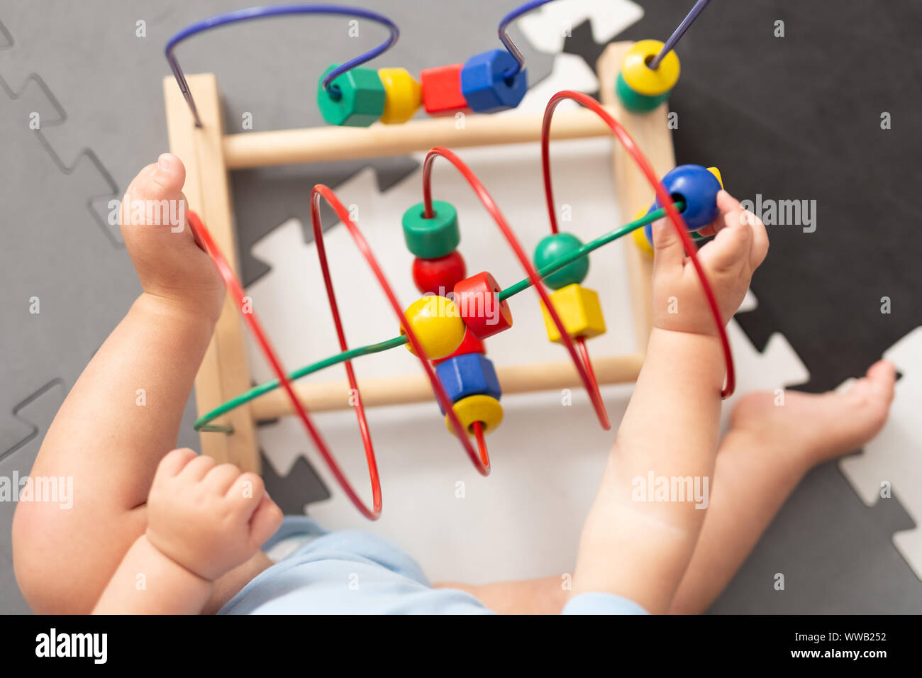 Baby playing with educational toy in nursery. Learning colorful wooden ...