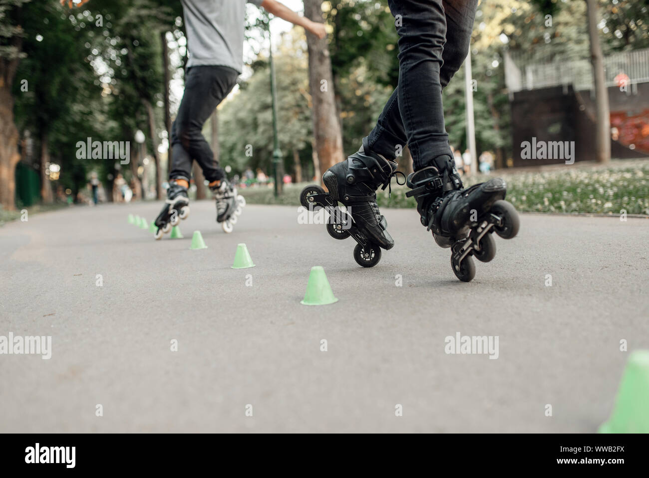 Roller skating, two skaters rolling around cones Stock Photo - Alamy