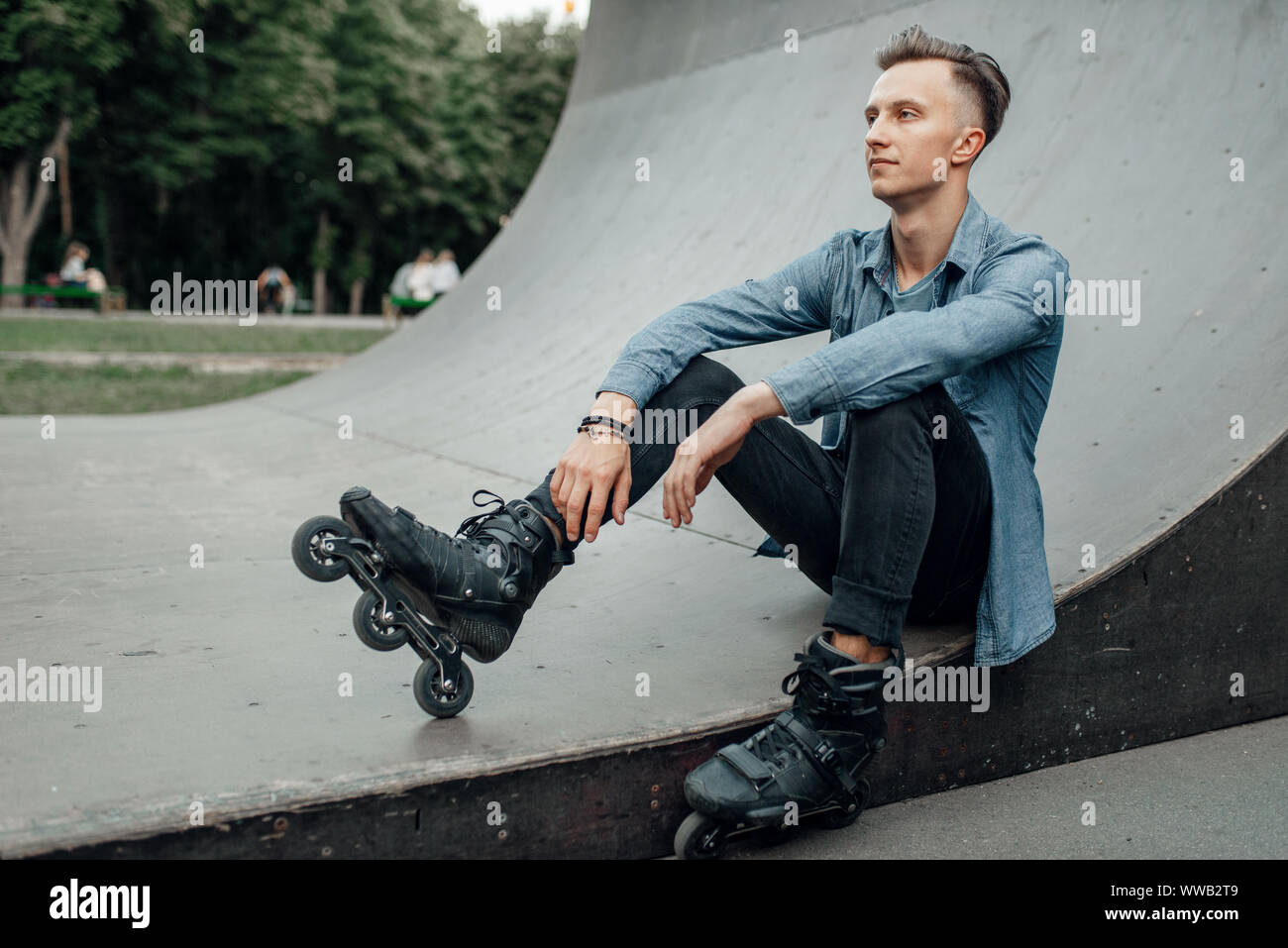 Roller skating, male skater poses on the ramp Stock Photo - Alamy