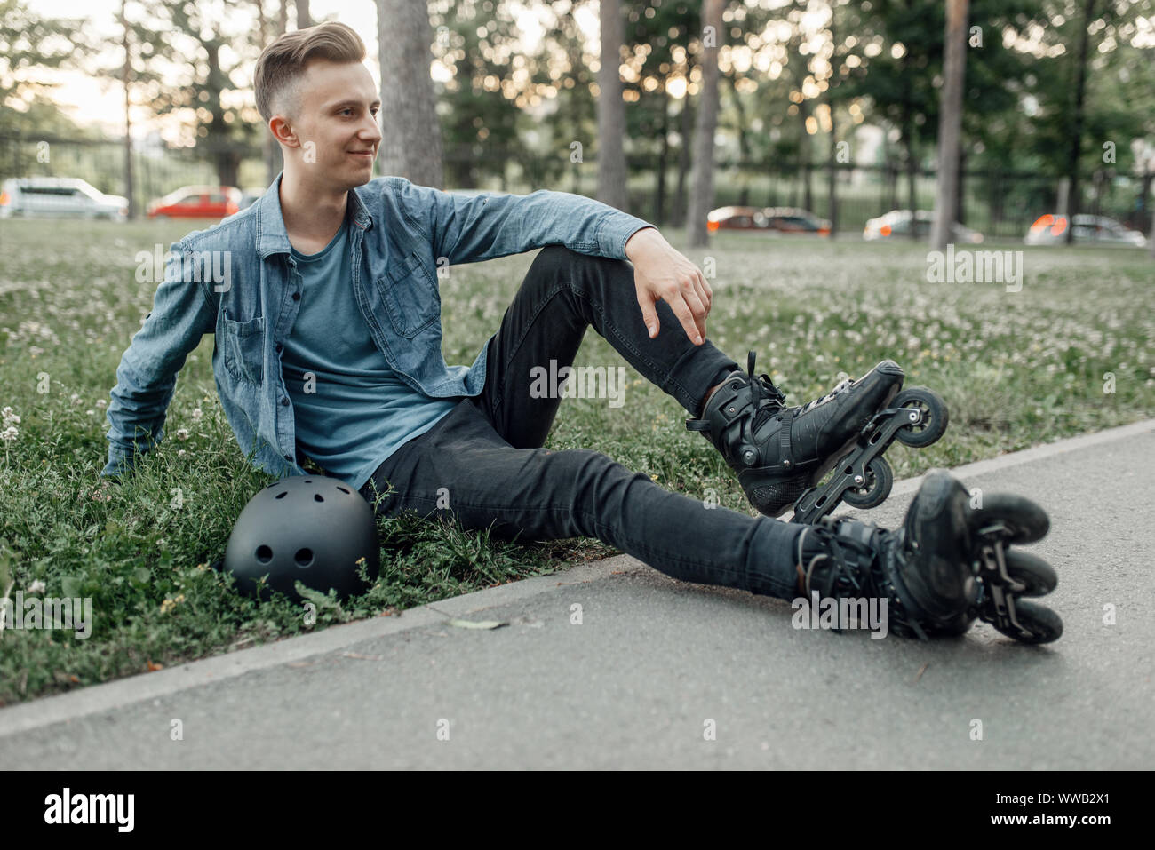 Roller skating, young skater sitting on the ground Stock Photo - Alamy