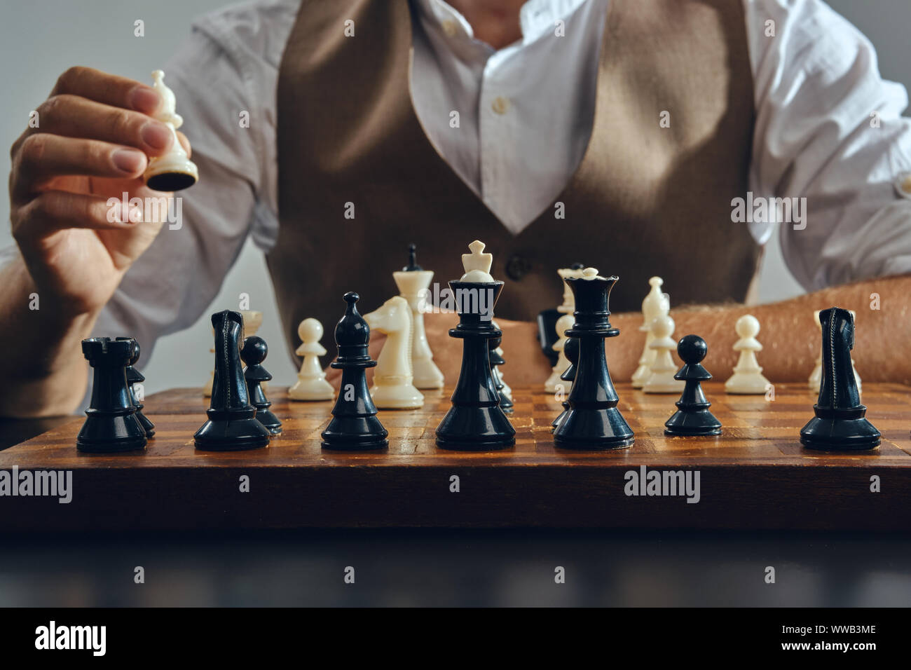 Hands of a man, dressed in a classic brown vest and white shirt siting ...
