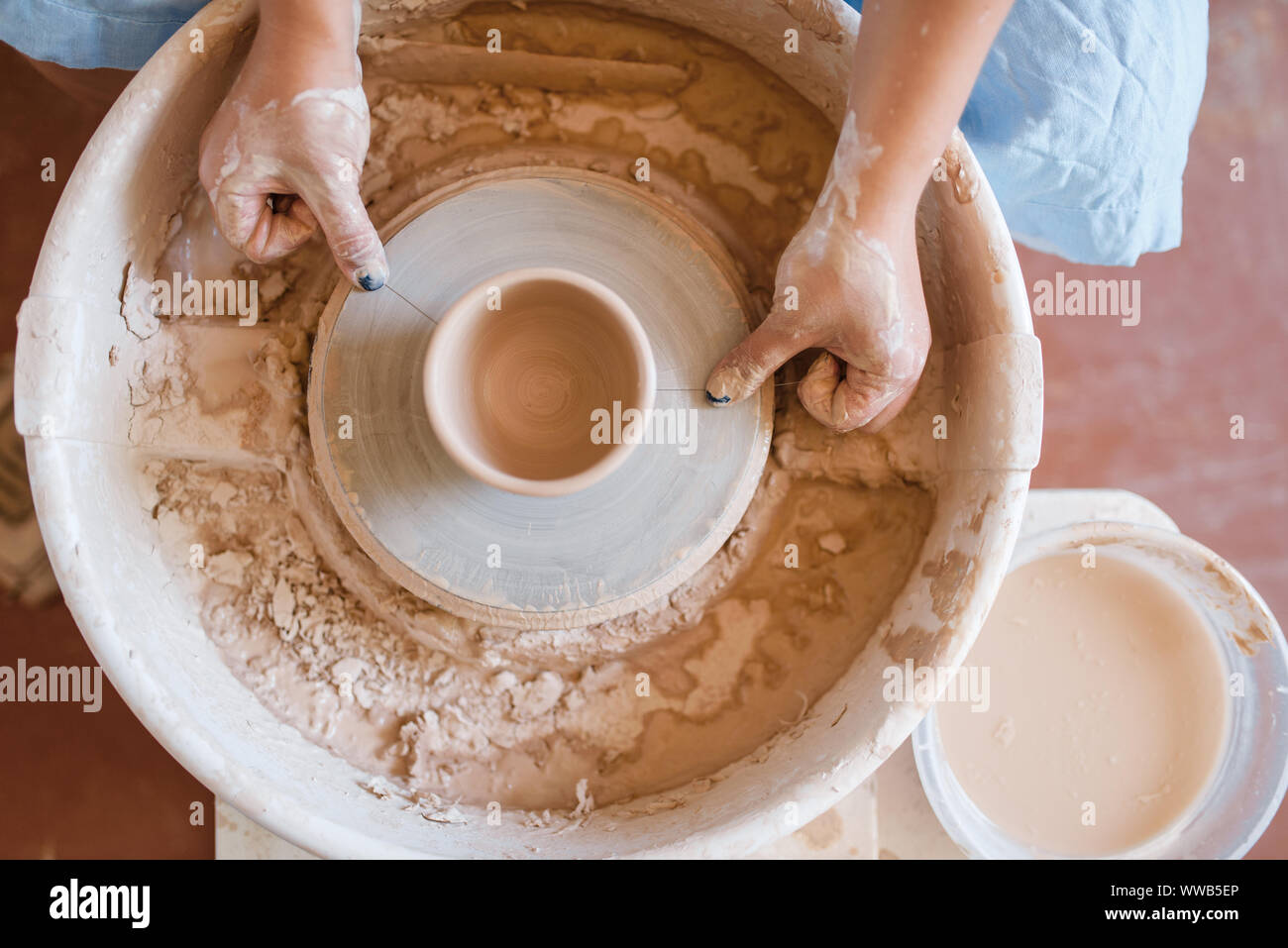 Master making a pot on pottery wheel, top view Stock Photo - Alamy