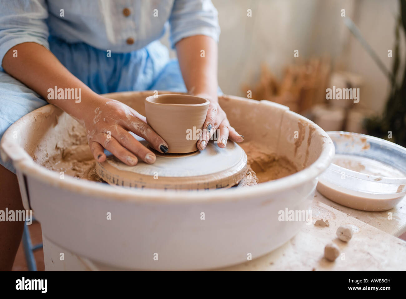 Female master holds wet pot over the pottery wheel Stock Photo - Alamy