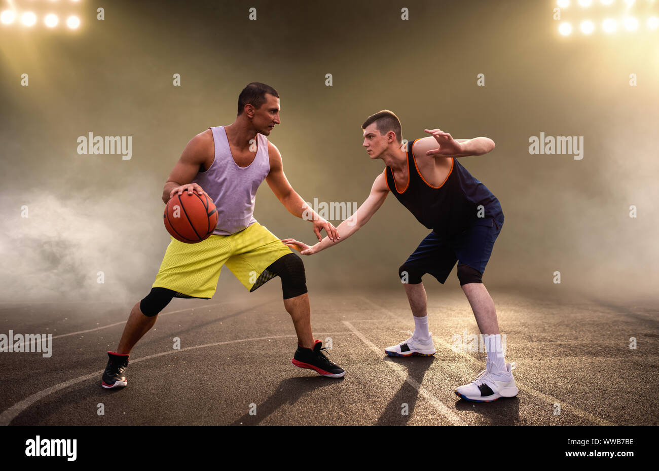 Two basketball players playing the game on court Stock Photo - Alamy
