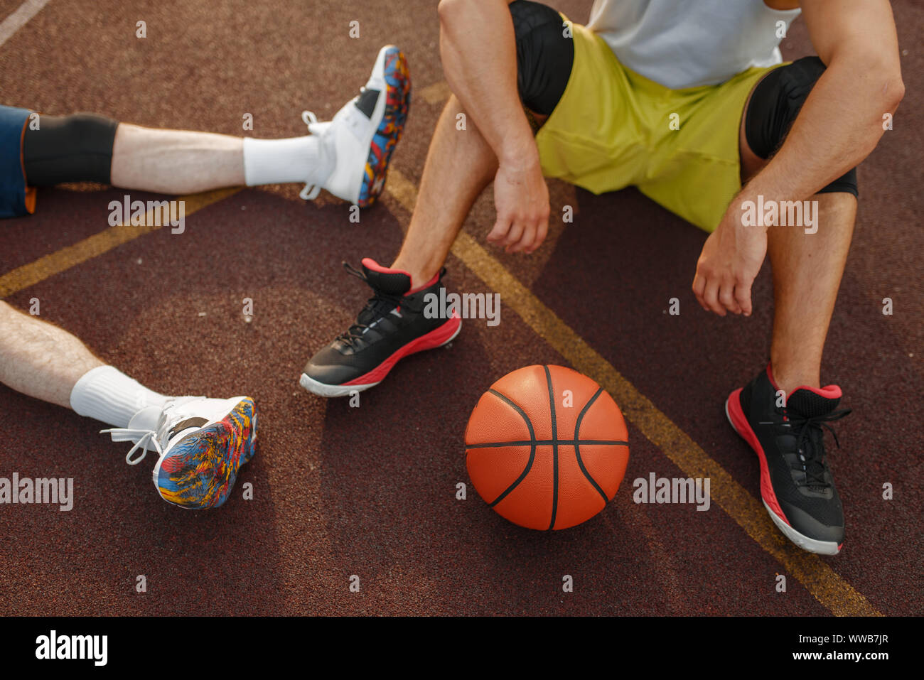 Basketball players sitting on the ground outdoor Stock Photo - Alamy