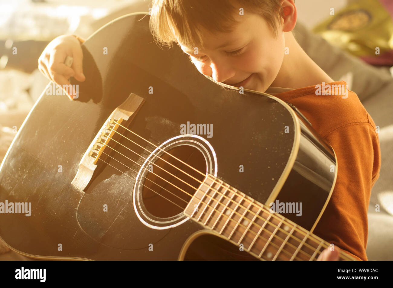 the boy plays a black acoustic guitar Stock Photo - Alamy