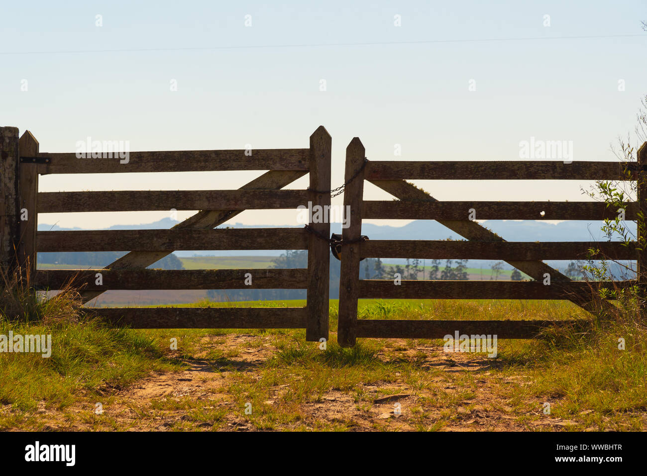 The entrance to the farm is closed and padlocked. Rural landscape in ...