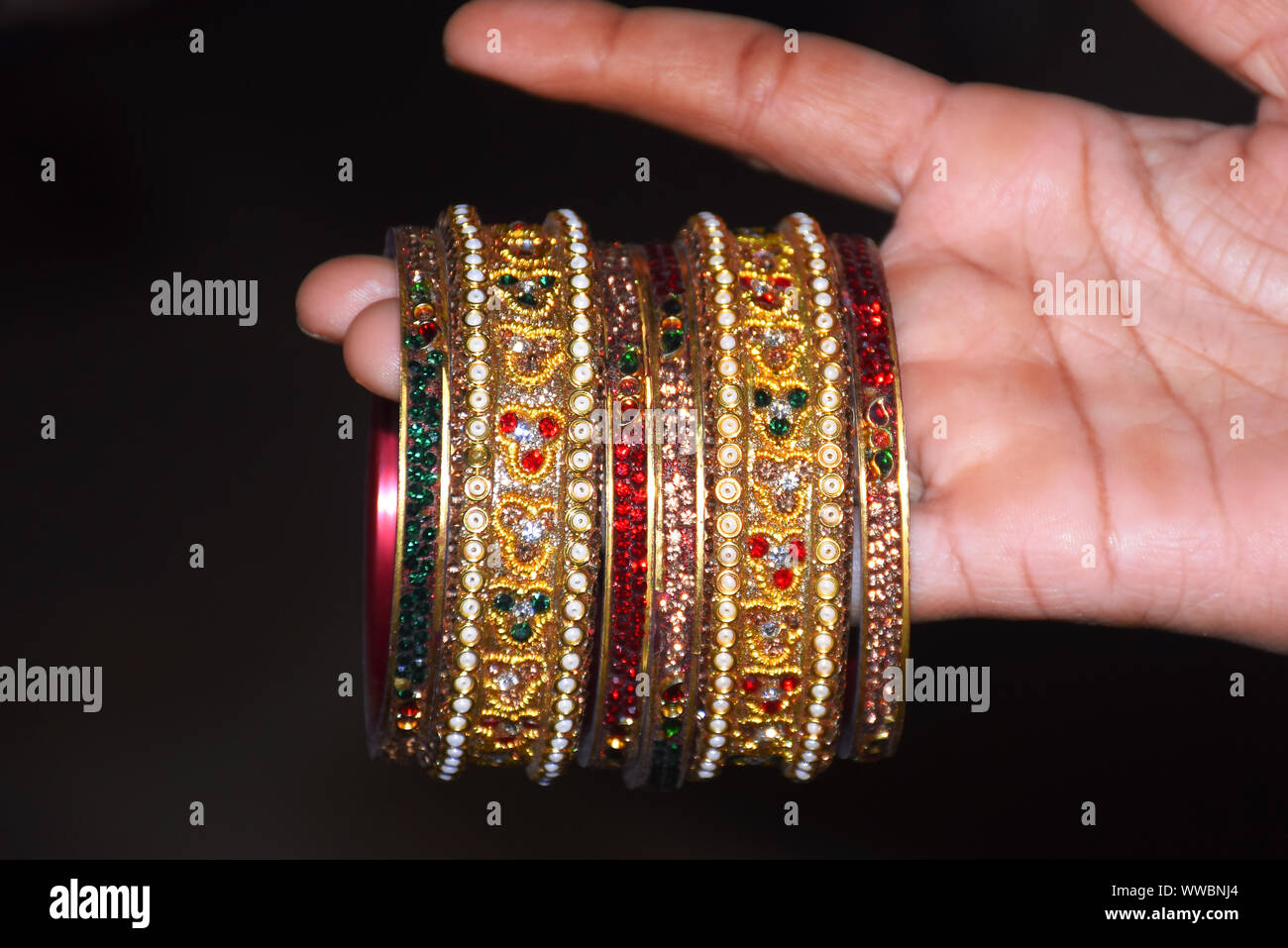 indian woman's hand holding bangle's with black background Stock Photo ...