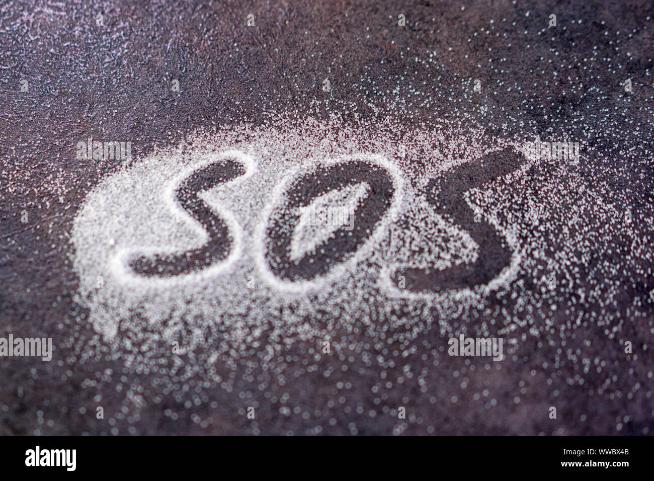 SOS word hand written on white powder, distress signal Stock Photo - Alamy