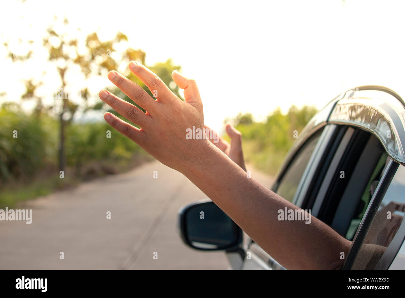 Man feeling the wind through his hands while driving in the country ...