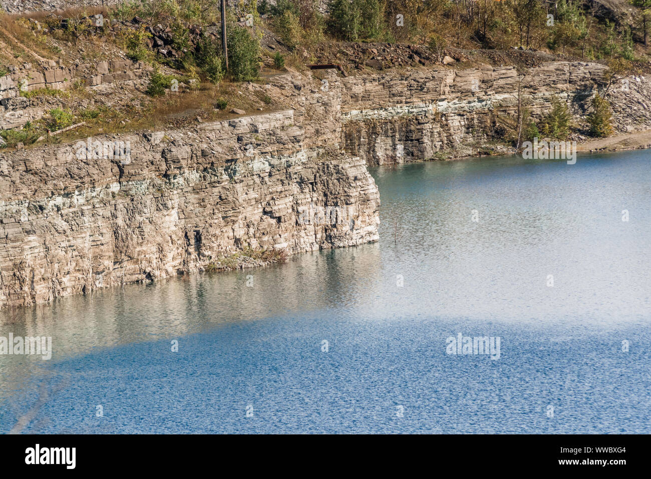 Close up of rocky wall strata showing different layers of green and ...