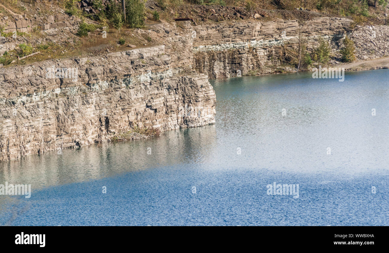 Close up of rocky wall strata showing different layers of green and ...