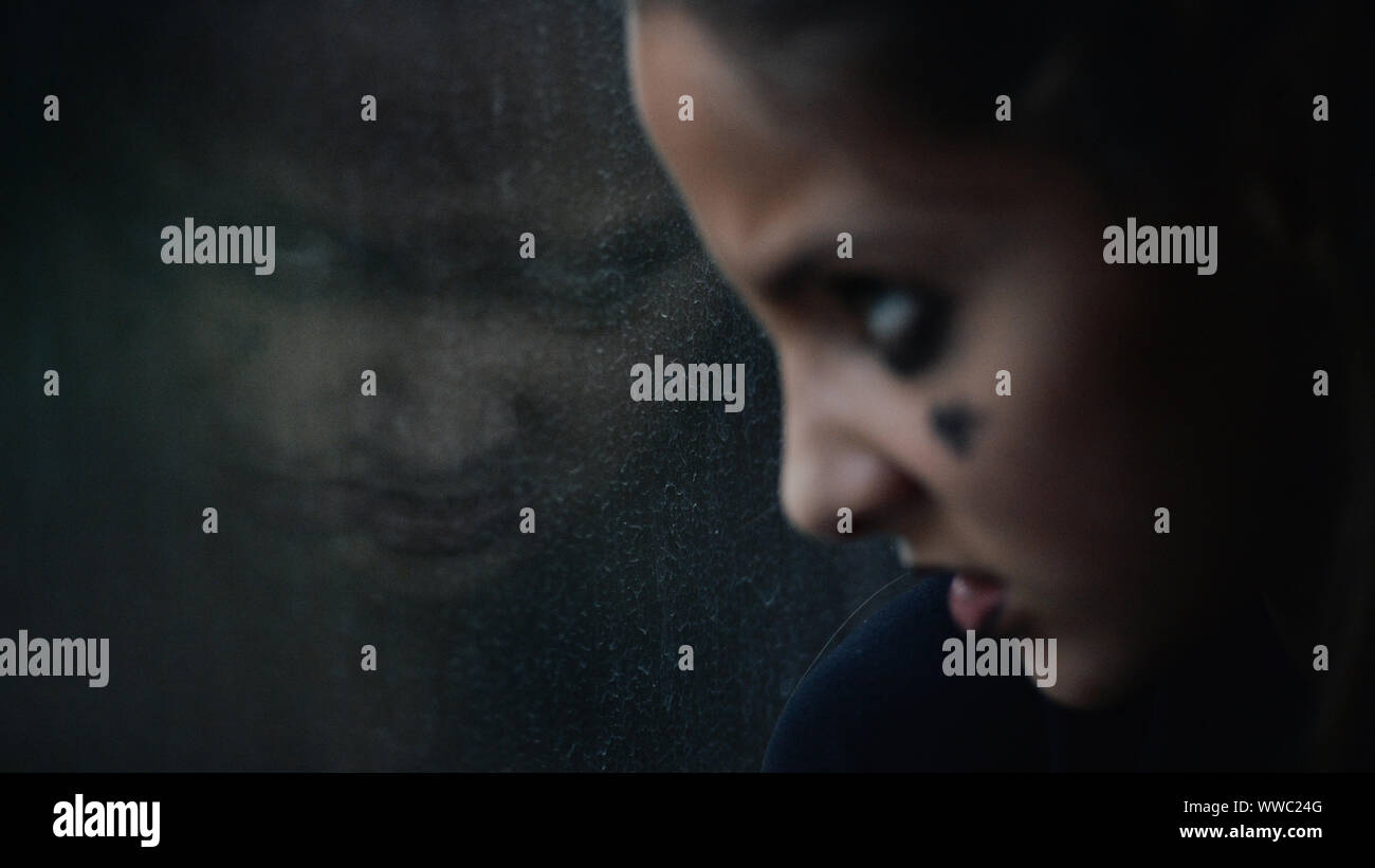 angry face of young little caucasian girl wearing dark youth subculture ...