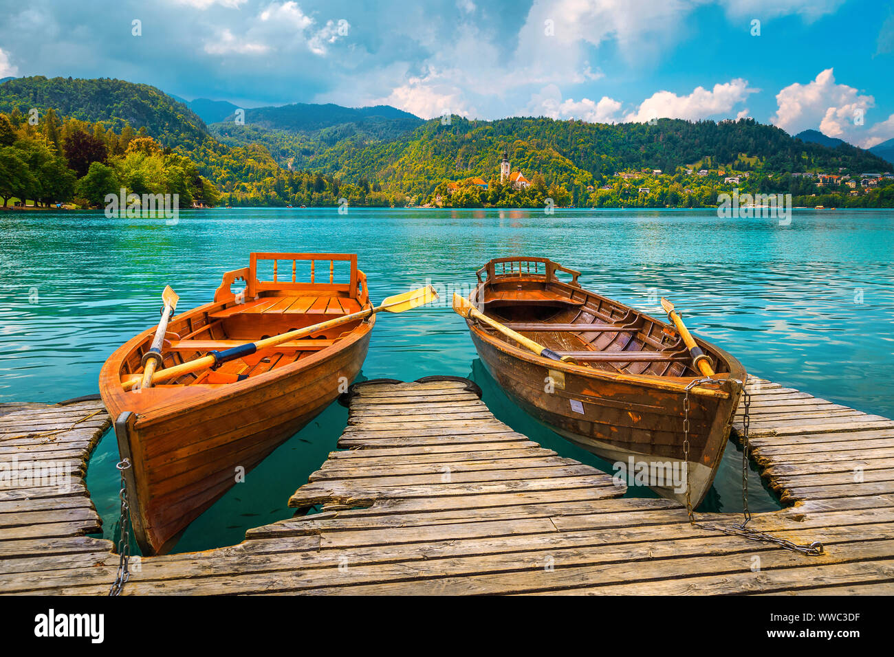 Cute wooden rowing boats anchored at the pier on the lake Bled. Famous ...