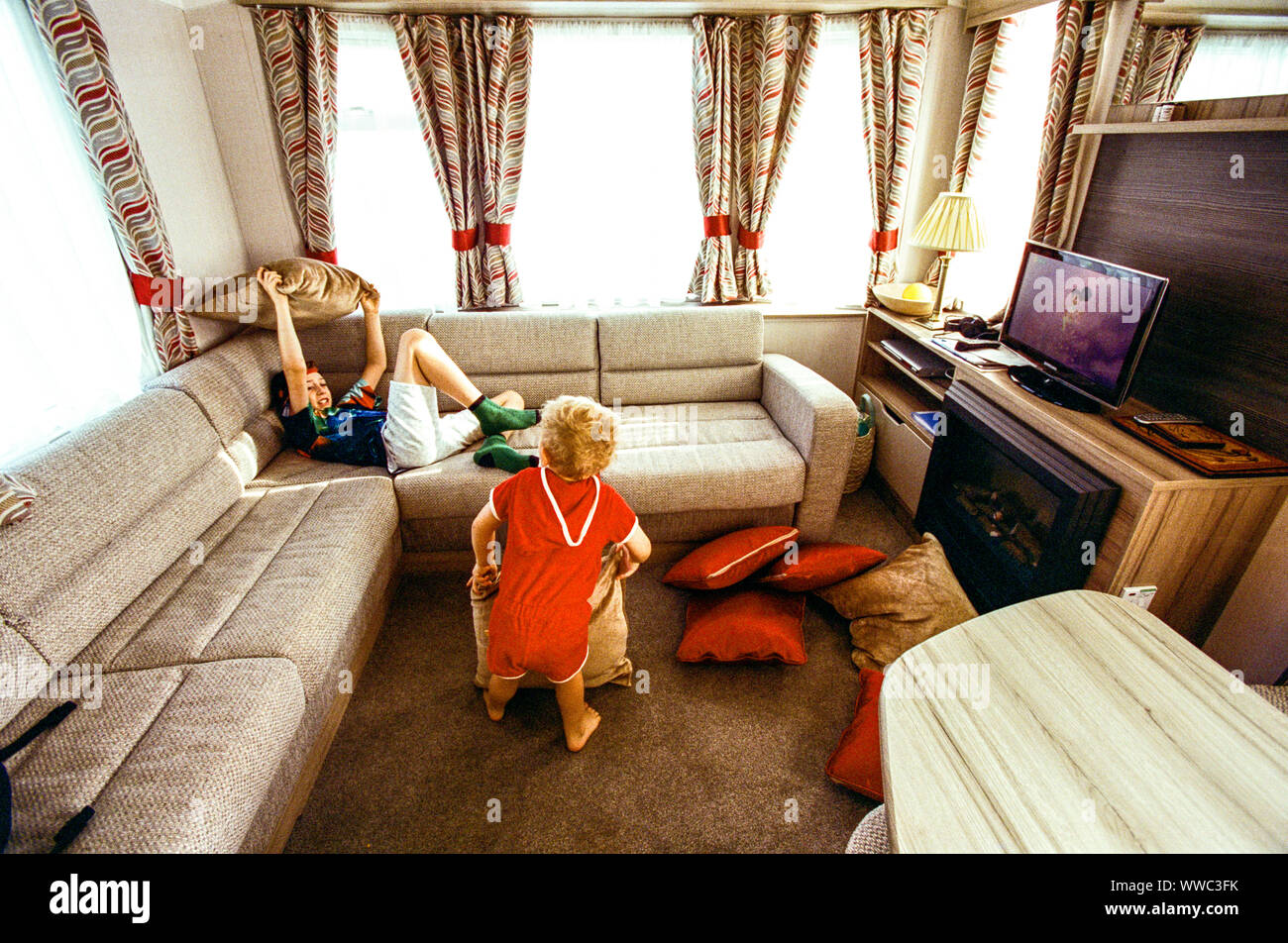 Two boys playing inside a static caravan at Karageen camp site ...