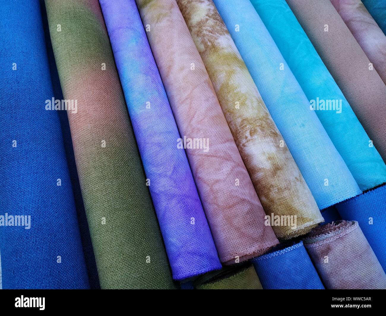 Rolls of colorful fabrics. Dyed fabric for sewing. Cross stitch fabric ...