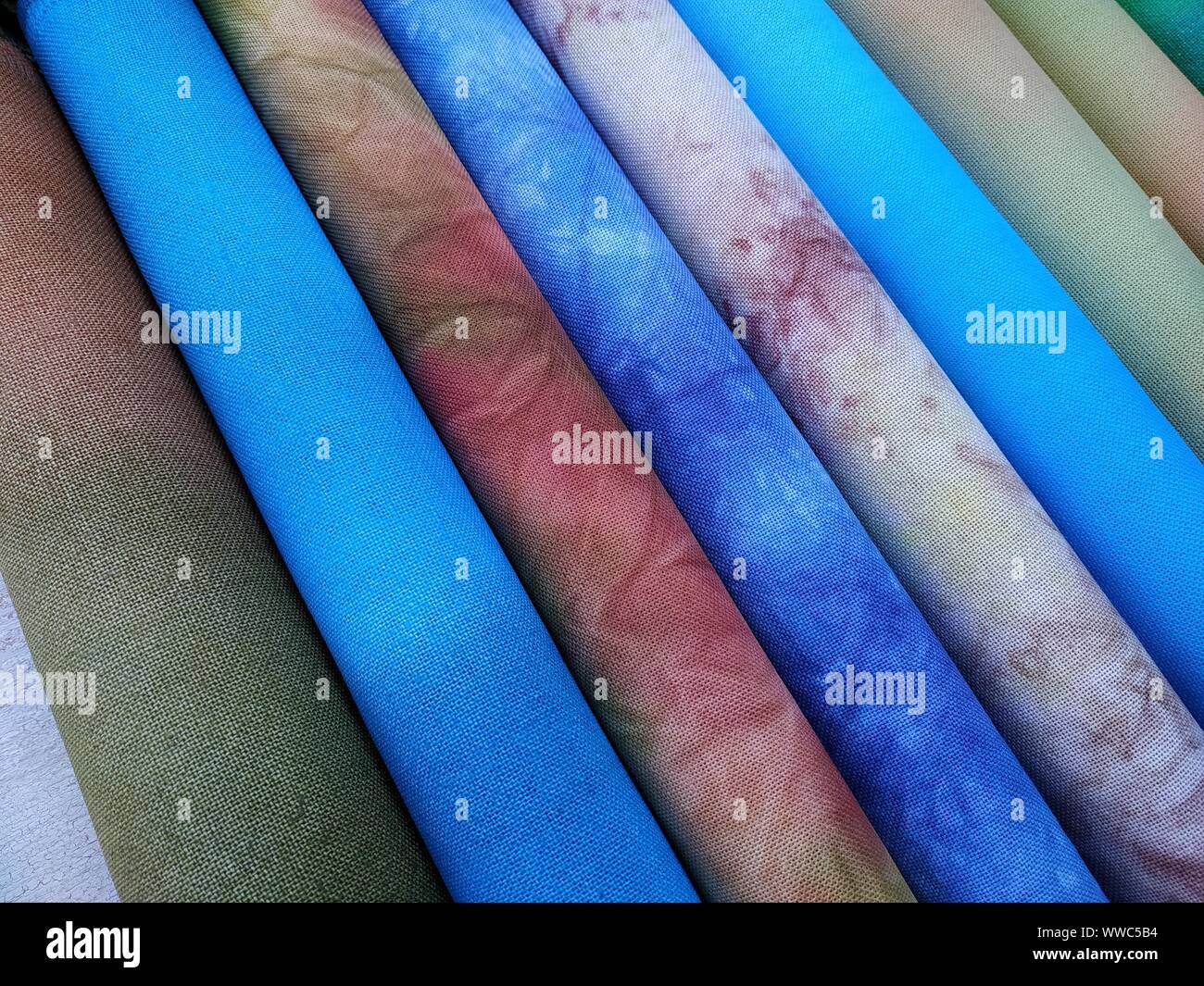 Rolls of colorful fabrics. Dyed fabric for sewing. Cross stitch fabric ...