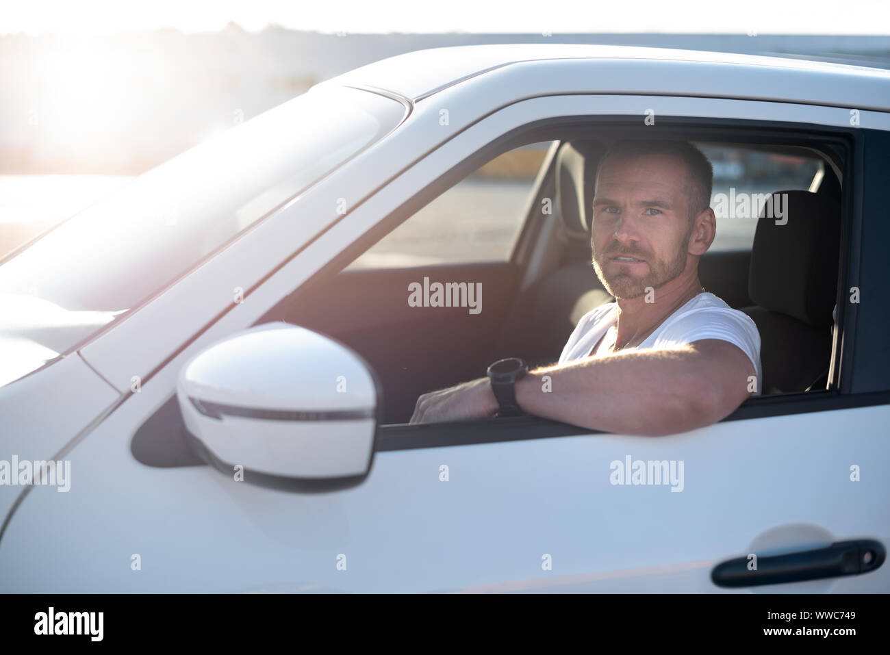 A man driving a white car Stock Photo - Alamy