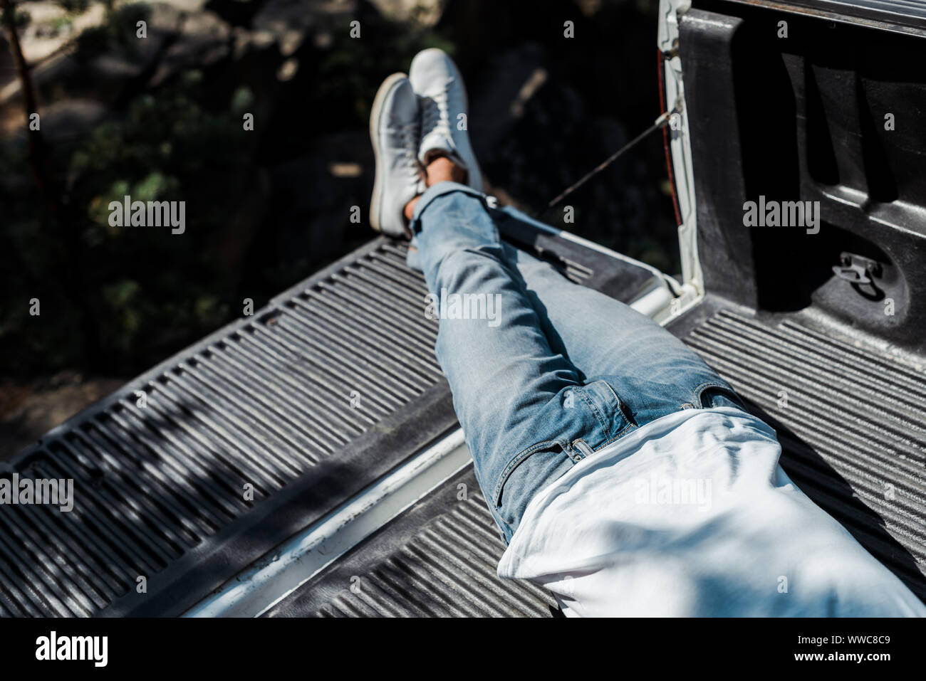 overhead view of man lying in blue denim jeans in car trunk Stock Photo ...