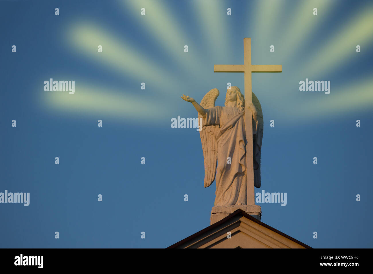 Statue of saint angel with cross and rays Stock Photo - Alamy