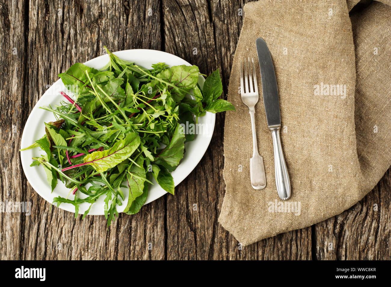 Green salad on rustic background with cutlery on canvas. Healthy food ...